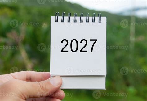 Hand Holding 2027 White Calendar With Nature Background Holiday And