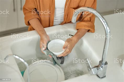 집안일 부엌 그리고 현대 집에서 위생과 청결을 위해 설거지를 하는 여자 하녀 청소부 주부는 집에서 비누 물 천으로 식기에 먼지를 청소합니다 20 24세에 대한 스톡 사진 및