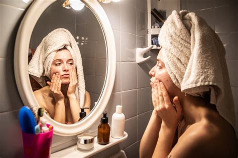 욕실 거울 앞에서 얼굴에 크림을 바르는 머리에 수건을 쓴 젊은 여자 25 29세에 대한 스톡 사진 및 기타 이미지 25 29세 가정 생활 가정의 방 Istock