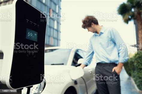 흐릿한 남자 배경이 있는 충전소에서 초점 Ev 자동차의 진보적인 개념 전기 연료 및 전력 생산에 대한 스톡 사진 및 기타 이미지