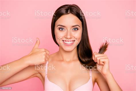 좋은 달콤한 사랑 스러운 매력적인 긍정적인 낙관적 명랑 소녀 베이 지 브래지어 들고 손에 엄지손가락 업 핑크 배경 위에 절연을 보여주는 빛나는 강한 부드러운 스트레이트 머리