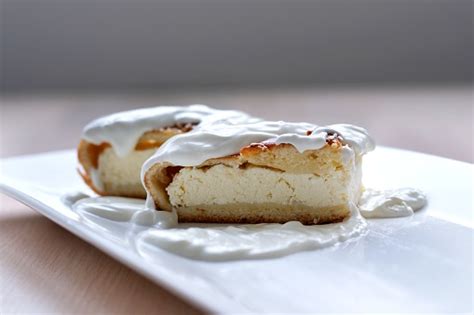 접시에 가루 설탕을 뿌린 부활절을위한 코티지 치즈의 코티지 치즈 캐서롤 조각이 잘립니다 클리핑 경로가있는 흰색 배경에 분리 된 수제 코티지 치즈 가루로 빻은에 대한 스톡