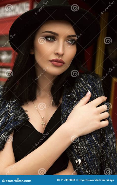 Красивая девушка с темными волосами в элегантных одеждах идя Стоковое Фото изображение