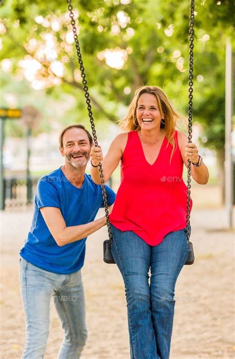 Married Mature 50s Couple Enjoy Happy In Playground Swing Seniors