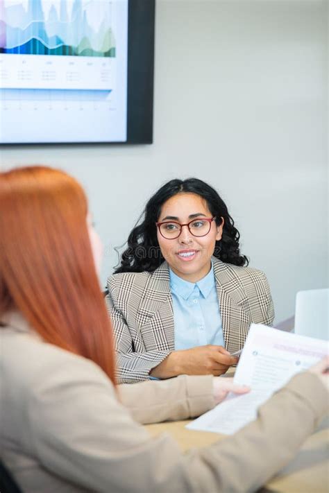 Young Women Working Together On A Collaborative Business Project In A