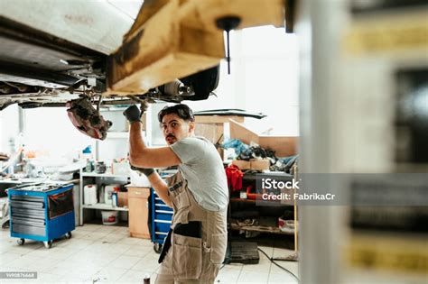 자동차 정비사는 자동차 서비스에서 자동차의 주행 장치를 수리합니다 25 29세에 대한 스톡 사진 및 기타 이미지 25 29세