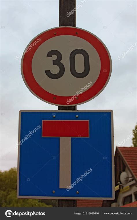 Two Road Signs On Post Against Cloudy Sky Represent Speed Limit And