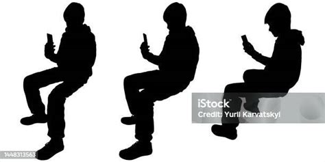 청소년과 휴대 전화 십대가 앉아서 한 손으로 휴대 전화를 잡고 화면을 봅니다 측면도 사람들은 스마트 폰을 사용합니다 셀룰러 장치를 가진 남성 고립된 블랙 실루엣 십대에 대한