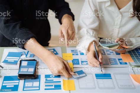 Ui 디자이너가 사무실에서 고객 브리프와 색상 코드를 사용한 모바일 앱 인터페이스 와이어프레임 디자인에 대해 브레인스토밍합니다