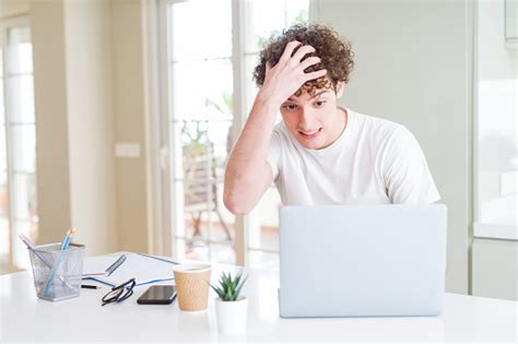컴퓨터 노트북을 사용 하 여 작업 하 고 공부 하는 젊은 학생 남자는 머리에 손으로 스트레스 수치심과 깜짝 얼굴 충격 화가 좌절 두려움과 실수에 대 한 화가 노트북에 대한