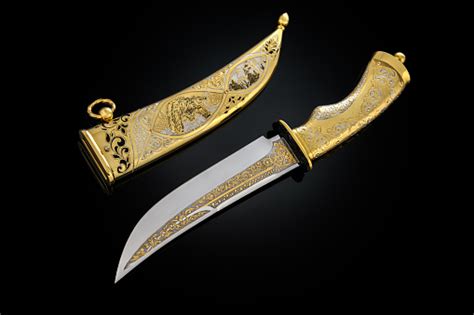 기념품 수집품 실버 골드 단검 커틀라스는 검은 색 배경에 금속 조각과 함께 칼집과 함께 제공됩니다 중세 빈티지 스타일의 전통적인 패턴을 가진 고급 무기 0명에 대한 스톡
