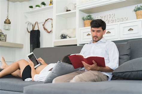 잘생긴 남편 책 및 아시아 임신 가정에서 거실에 있는 소파에 누워 태블릿 컴퓨터 재생 건강 하 고 행복 가족 Takecare의 개념입니다 가족에 대한 스톡 사진 및 기타