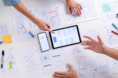 Ux Ui Designers Discussing And Brainstorming On Wireframes For A Website And Mobile App