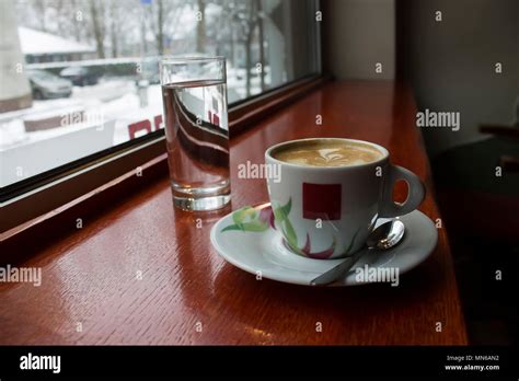 Fresh Brown Coffee With A Nice Drawing And A Glass Of Water On A Long