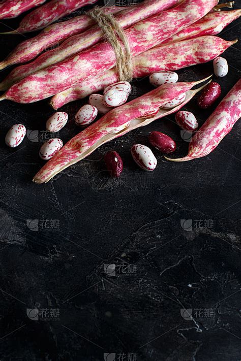 木桌上放着花斑豆和豆荚