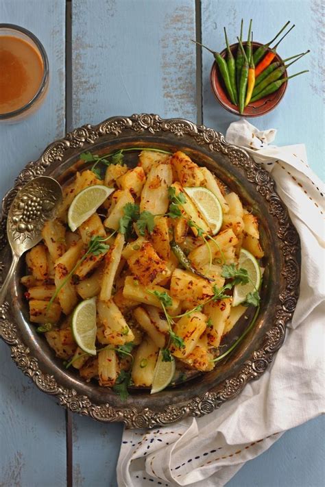 A Silver Plate Topped With Potatoes Covered In Lemons And Garnished With Cilantro