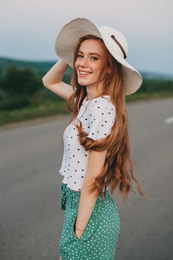 주근깨가 모자를 쓰고 시골에서 혼자 포즈를 취하고 웃으며 카메라를 바라 보는 빨간 머리 여자 여름 날씨 녹색 필드 매력적인 아름다운 소녀 20 24세에 대한 스톡 사진 및