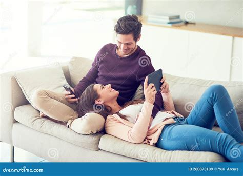 Sharing More Than One Connection A Smiling Young Couple Using Digital
