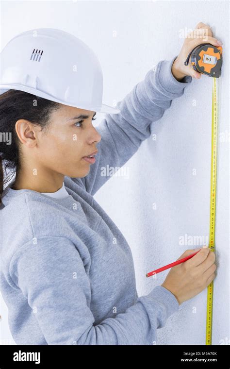Woman Measuring Wall And Marking Position With Pencil Stock Photo Alamy