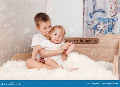 Older Brother Tickles Younger Sister`s Bare Feet On Bed At Home Stock Image Image Of Girl