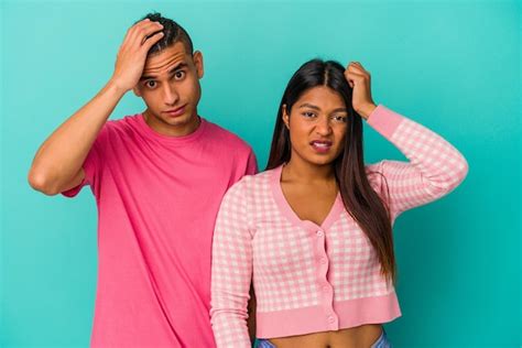 Jeune Couple Latin Isolé Sur Fond Bleu étant Choqué Elle Sest