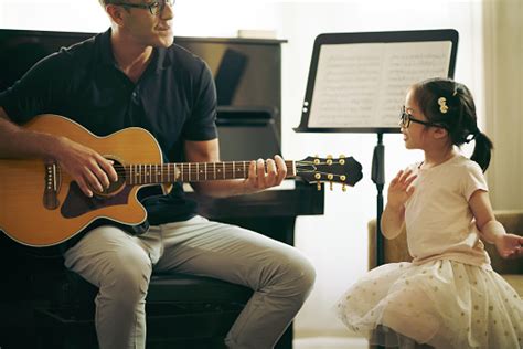 음악 수업과 재미를 여자 아이 유아의 장면 음악 교사와 사랑스러운 어린 소녀는 함께 노래를 노래하는 동안 기타를 연주 아이 뇌 개발 개인 수업 학교로 돌아가기 2명에 대한