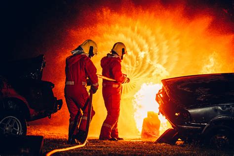 물과 소화기로 불길과 싸우는 용감한 소방관들 팀워크와 용기로 화재를 진압하는 소방관 강도 높은 소방 훈련 2명에 대한 스톡 사진 및 기타 이미지 Istock