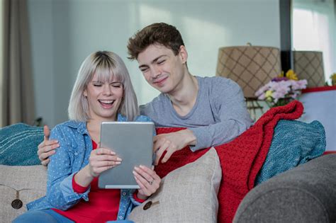 집 거실에서 귀여운 젊은 성인 커플 디지털 태블릿을 함께 사용 2명에 대한 스톡 사진 및 기타 이미지 2명 가정 생활