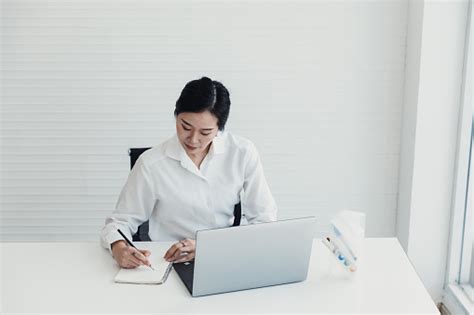 밝고 현대적인 사무실 공간에서 노트북으로 작업하면서 메모를 쓰는 전문 여성 25 29세에 대한 스톡 사진 및 기타 이미지 25 29세 계획 공부 Istock