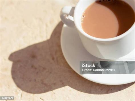 아침 햇살에 하얀 컵에 우유를 곁들인 차 질감이 있는 나무 표면에 가혹한 그림자가 드리우고 있습니다 따뜻한 색조 0명에 대한 스톡 사진 및 기타 이미지 Istock