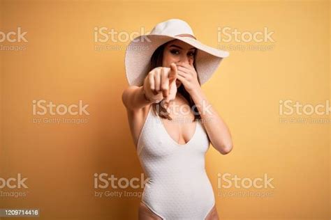 젊은 아름 다운 갈색 머리 여자 에 휴가 착용 수영복 과 여름 모자 웃음 가리키는 손가락 으로 카메라에 카메라 위에 입 수치