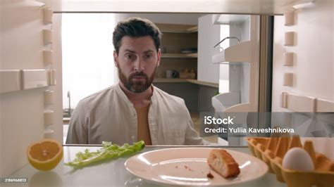 Pov 냉장고 관점에서 냉장고 내부에서 계란 양상추 반 레몬 백인 혼란스러워하는 남자 성인 남성 남자 오렌지 주스의 빈 병을 먹고 빵 부스러기 음식 배달 슈퍼마켓 가정