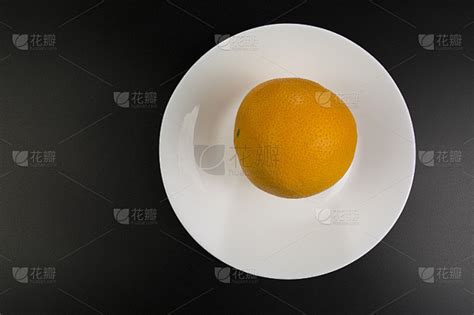 一个多汁的橘子躺在盘子里