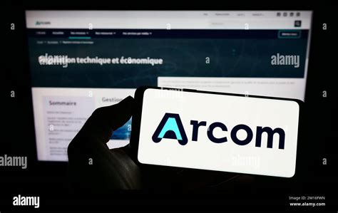 Person Holding Cellphone With Logo Of French Digital Regulation Agency Arcom On Screen In Front