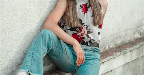 갈색 머리 개인 스타일 거리 거리 패션 귀걸이 꽃 무늬 낮 느긋한 데님 데님 팬츠 도시 설정 도시의 벽돌 벽 보도 사람 선명한 세련된 복장