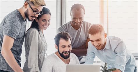 다섯 명의 다양한 사업가들이 사무실 회의실의 테이블에서 일하면서 노트북을 통해 함께 이야기합니다 사무실에서 함께 비즈니스 프로젝트를 진행하는 비즈니스 팀 오른쪽 상단