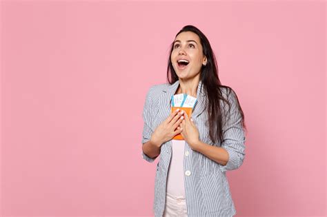 찾고 여권 스튜디오에서 분홍색 파스텔 배경에 고립 된 탑승권 티켓을 들고 줄무늬 재킷에 흥분 젊은 여자 사람들은 진심으로 감정 라이프 스타일 개념입니다 복사 공간을 모의