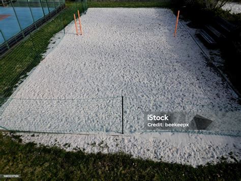 화이트 샌드 비치 발리볼 코트 그물로 울타리가 있는 흰색 부드러운 모래 언덕 경기장의 라인은 파란색 섬유 플라스틱 스트랩으로