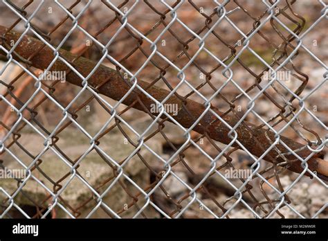 Rusty Chain Link Fence With A Brown And Grey Urban Background Blurred