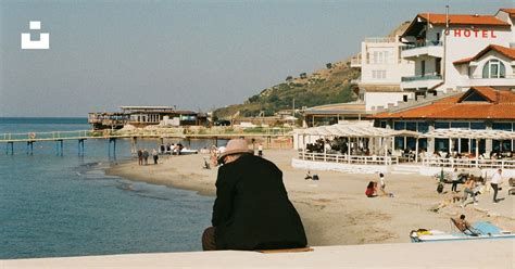 해변에 앉아 바다를 바라보고 있는 사람 사진 Unsplash의 무료 필름 사진 이미지