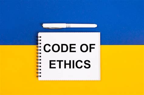 Premium Photo A White Notebook With The Text Code Of Ethics And A White Pen On A Blue And