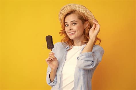 Young Woman Eat Ice Creams With Chocolate Glaze On Yellow Background