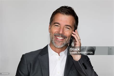 잘 생긴 성숙한 행복한 남자 카메라에 미소 그는 전화에 있습니다 좋은 소식 흰색으로 분리 40 49세에 대한 스톡 사진 및 기타 이미지 Istock