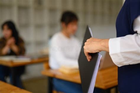 Cropped Shot Of Professor Walking Around Classroom While Assisting Her