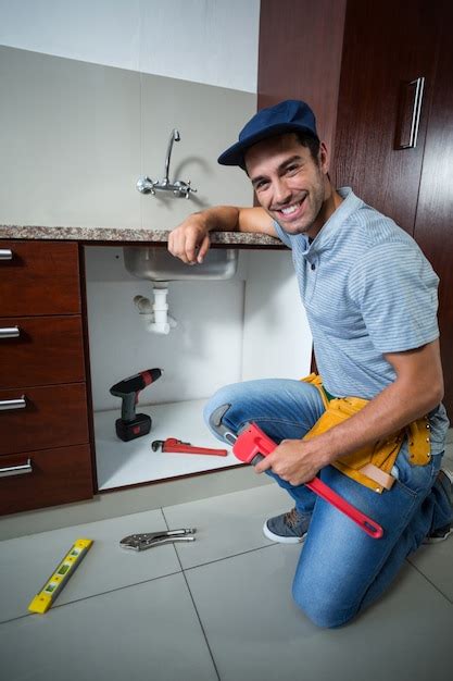 Premium Photo Portrait Of Happy Man Holding Pipe Wrench