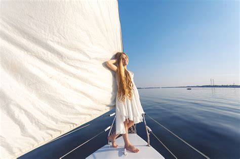 하얀 드레스와 여름에 요트에 긴 곱슬 금발 머리 서 행복 이빨 웃는 예쁜 여자의 초상화 그녀의 머리를 만지고 하 고 카메라를 보고 강에 대한 스톡 사진 및 기타 이미지