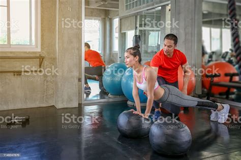 트레이너는 밀고가 르 친다 트레이너를 교정 하는 동안 여자는 밀어 업을 하 고 위치 하드 서 스 펜 션 훈련에서 여성에 게 남성 개인 트레이너 교육 린 바닥 자세로 운동