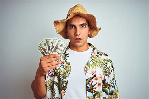 휴일에 젊은 남자 보유 달러 지폐 위에 흰색 고립 된 배경 에 무서운 충격에 충격 두려움과 두려움 표현흥분 감정에 대한 스톡 사진 및 기타 이미지 Istock
