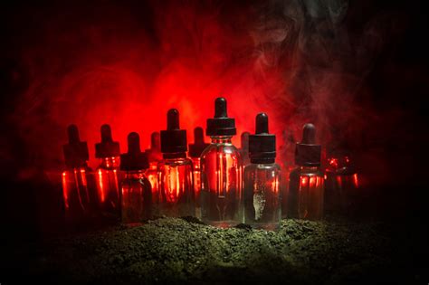 Vape 개념입니다 구름과 어두운 배경에 Vape 액체 병 연기 빛 효과입니다 배경 또는 Vape 광고 Vape 배경으로 유용 합니다 0명에 대한 스톡 사진 및 기타 이미지