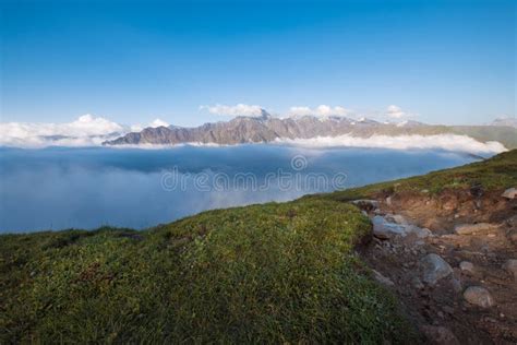 Большие горы Каукасуса покрытые вечерними облаками с вершением 4451m туристический путь